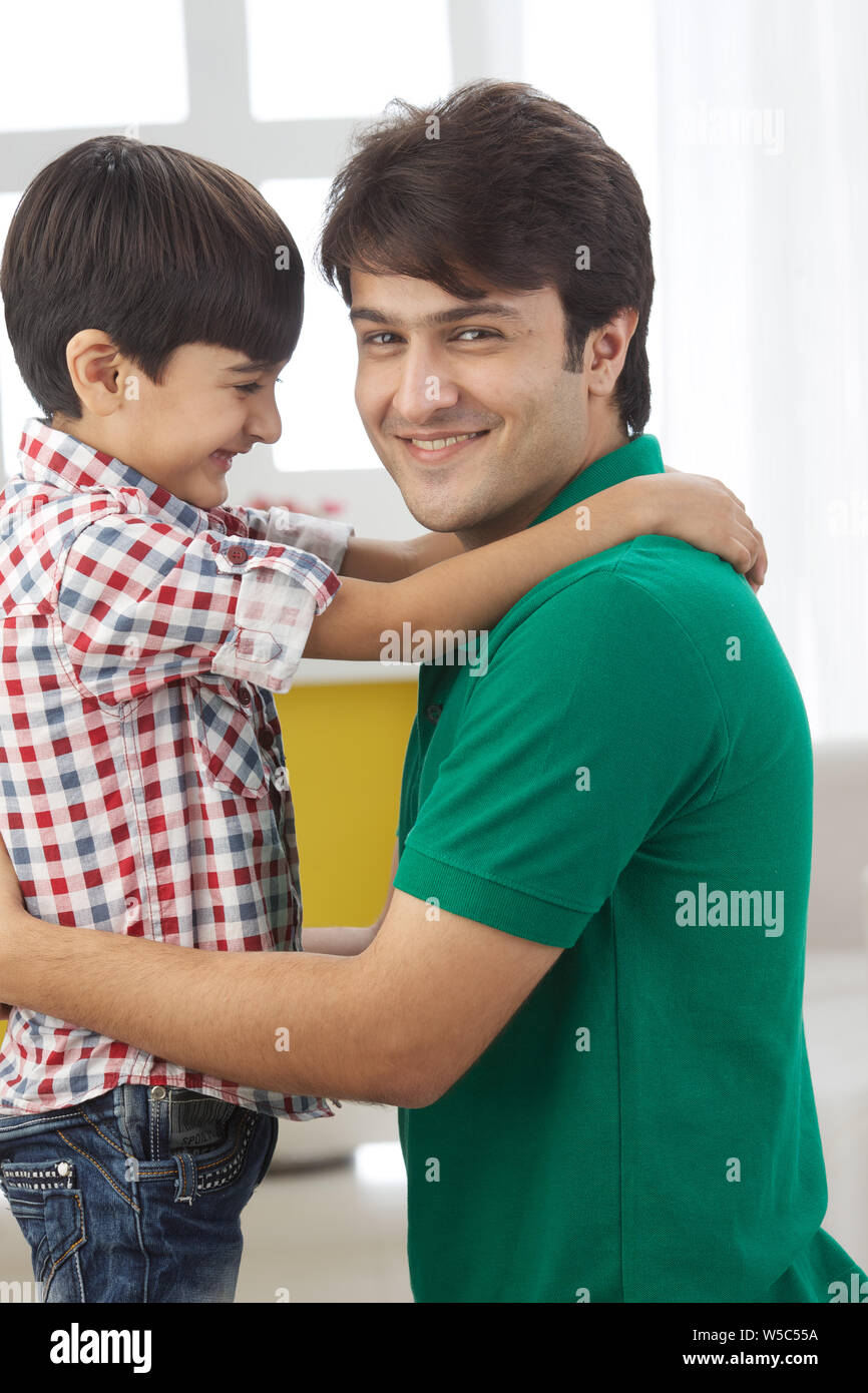 Man hugging his son and smiling Stock Photo - Alamy
