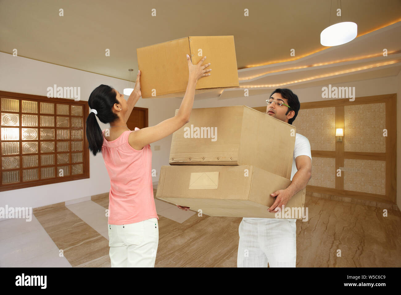 Couple carrying moving boxes into new home Stock Photo - Alamy