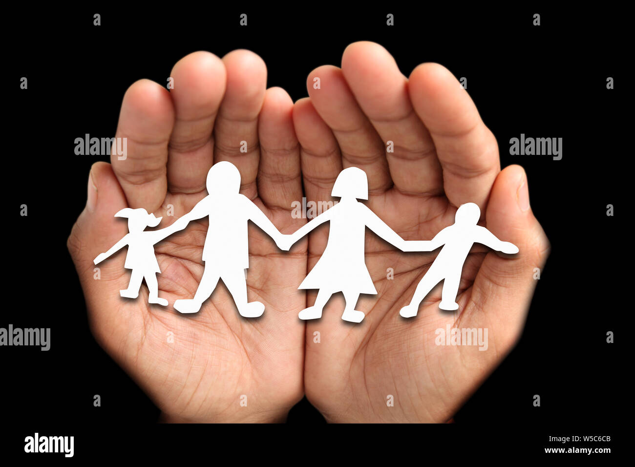 Person hand holding figures representing family Stock Photo - Alamy