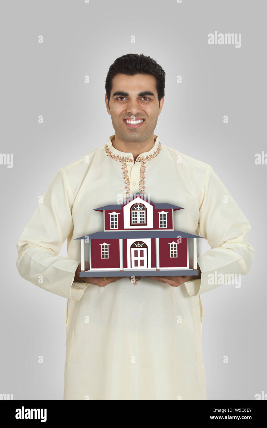 Man showing dream home and smiling Stock Photo - Alamy