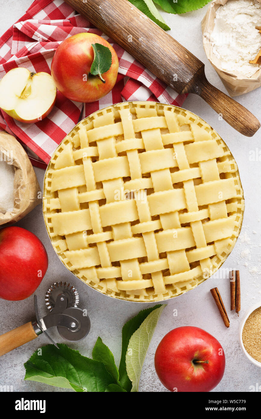 Making apple pie with lattice top. Raw unbaked apple pie with tools and ...