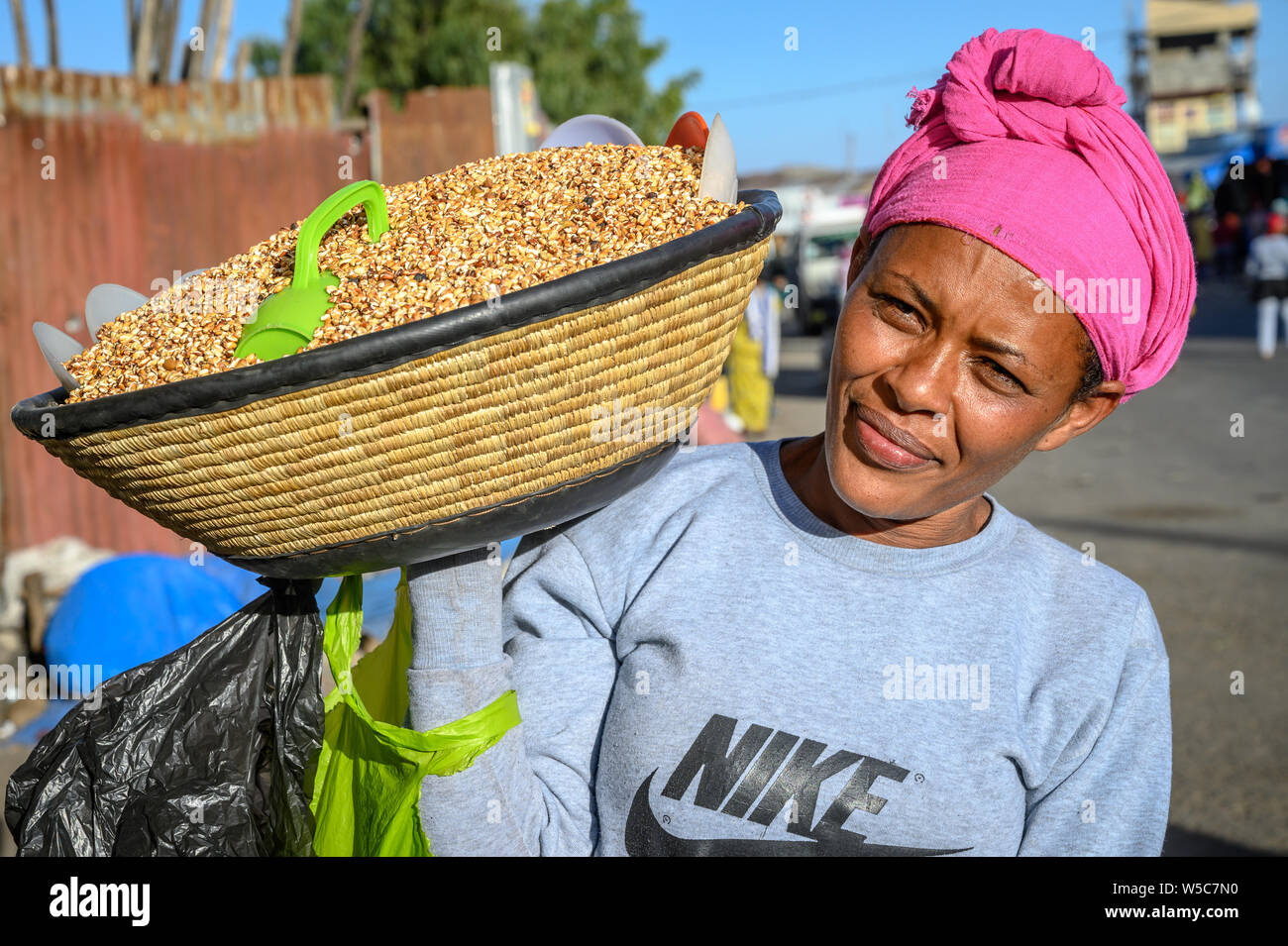 Woman carrying basket full of Kolo or roasted barley on her shoulder ...