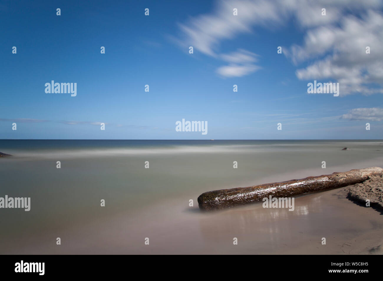 Wood log in the ocean Stock Photo - Alamy