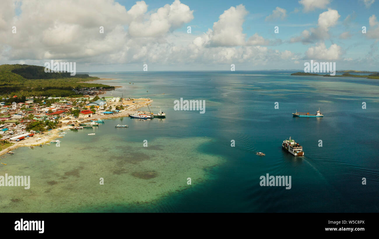Passenger port with ferries and cargo ships on the island of Siargao ...