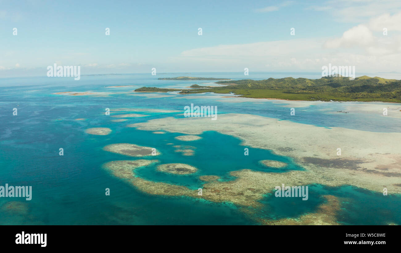 Islands are surrounded by an atoll and a coral reef with blue water top ...