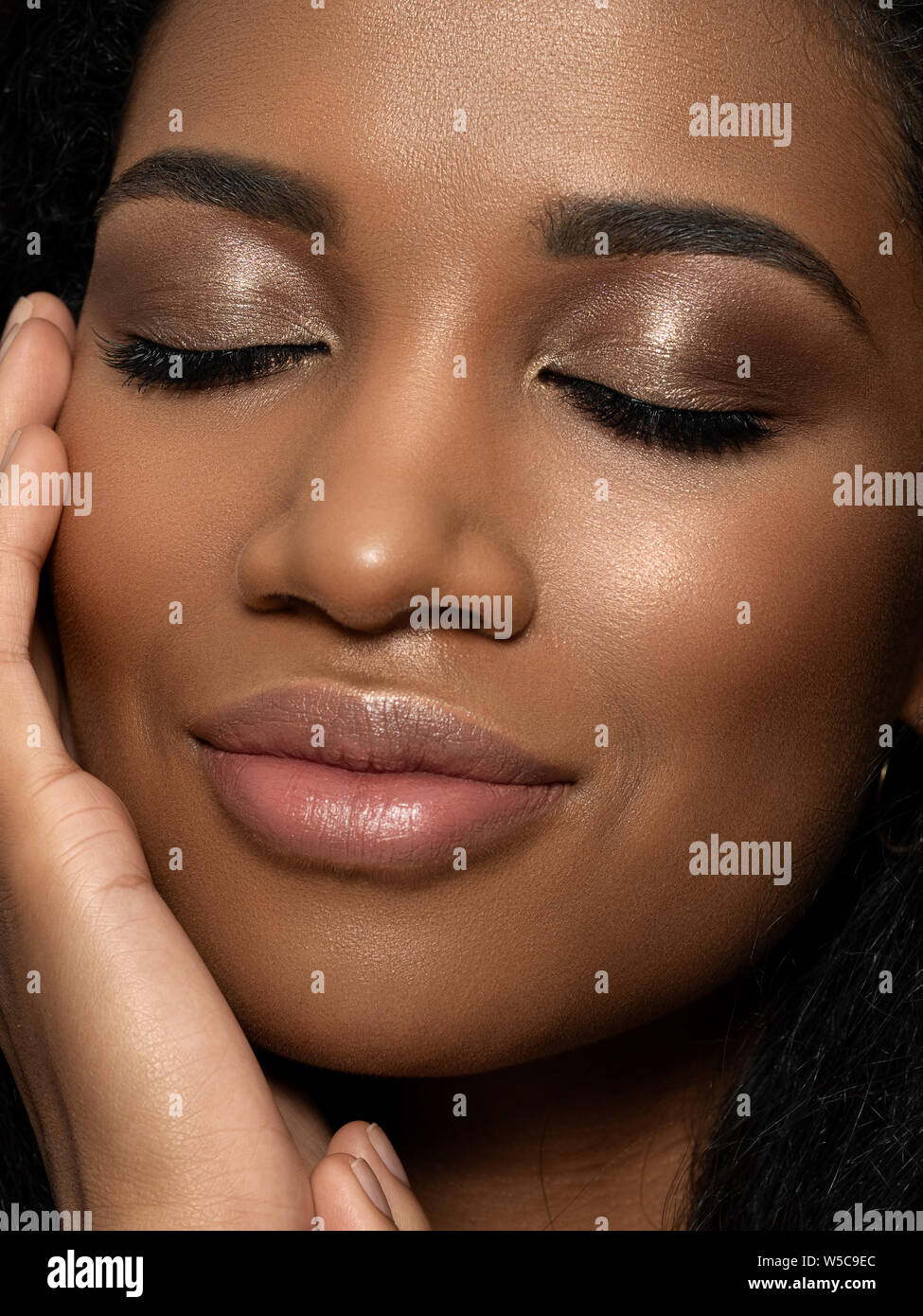 Young beautiful black woman touching her face Stock Photo - Alamy