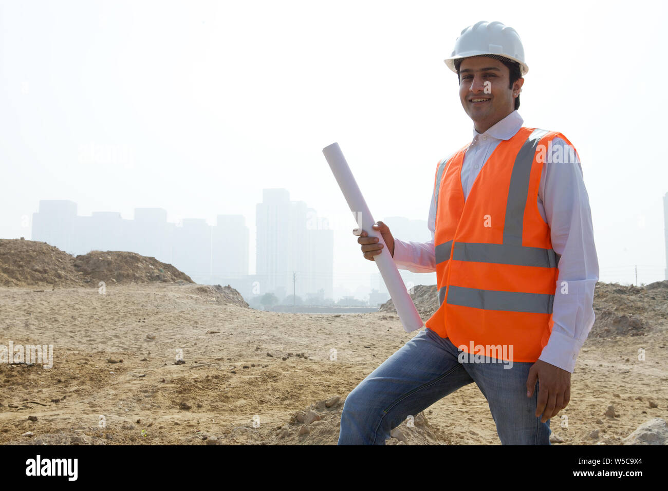 Architect holding blueprint at construction site Stock Photo - Alamy