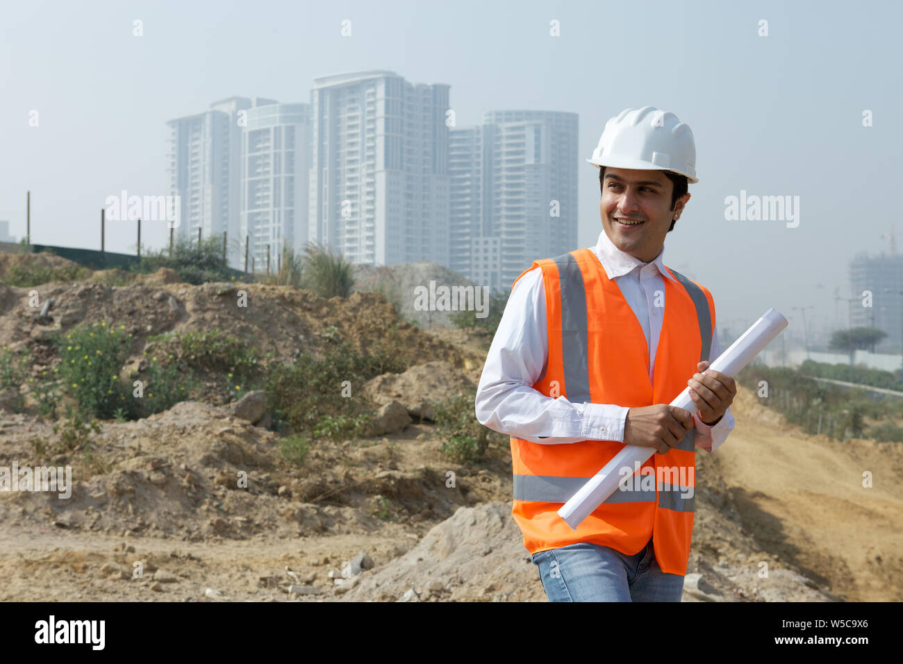 Architect holding blueprint at construction site Stock Photo - Alamy