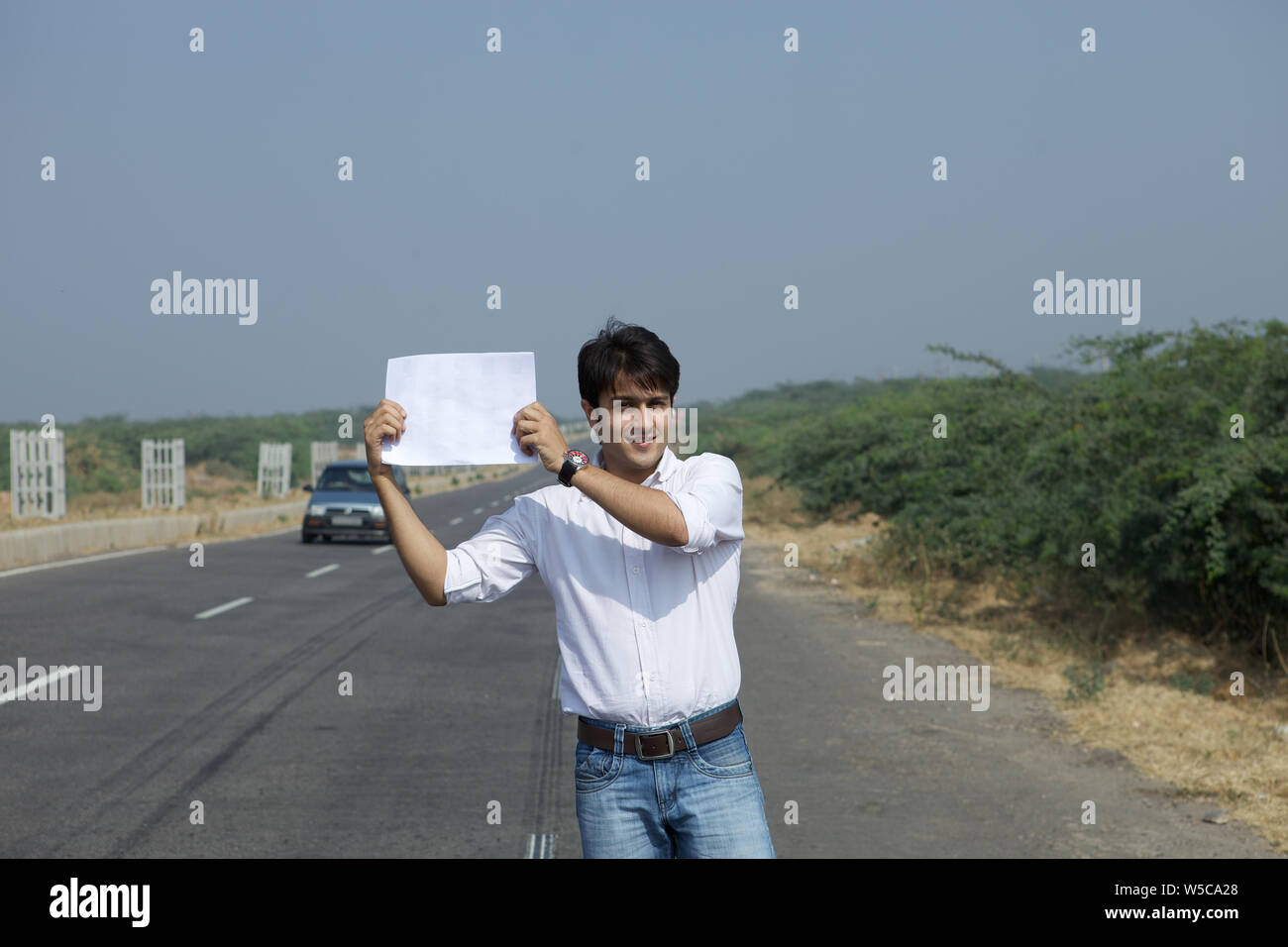 Man holding blank sign at roadside Stock Photo - Alamy