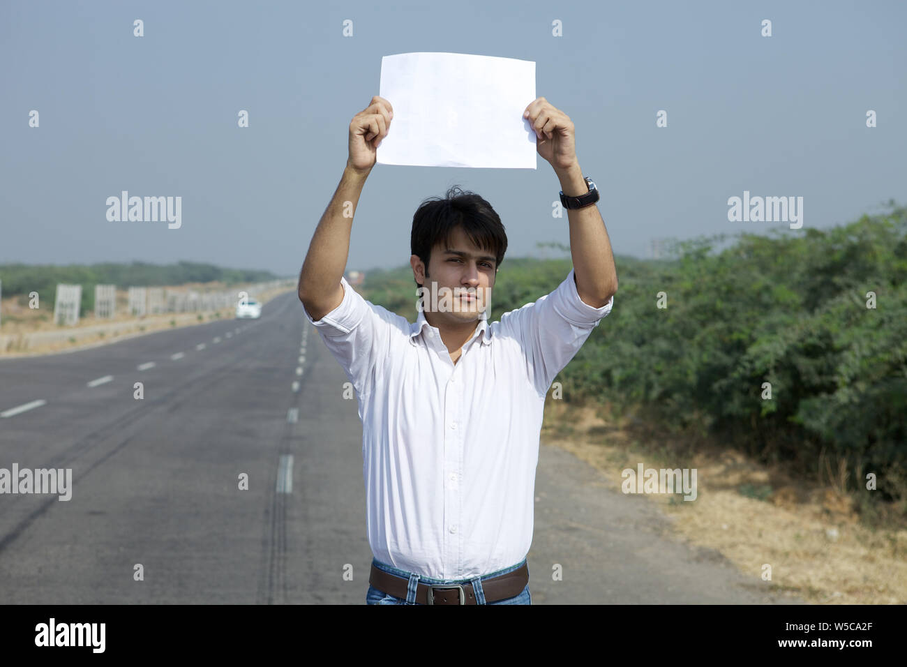 Man holding blank sign at roadside Stock Photo - Alamy