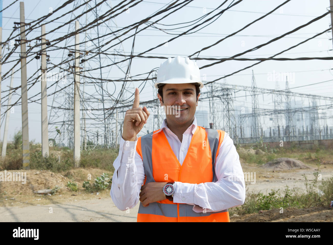 Engineer pointing upward and smiling Stock Photo - Alamy