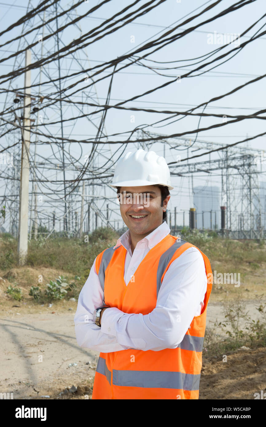 Engineer standing with arms crossed and smiling Stock Photo - Alamy