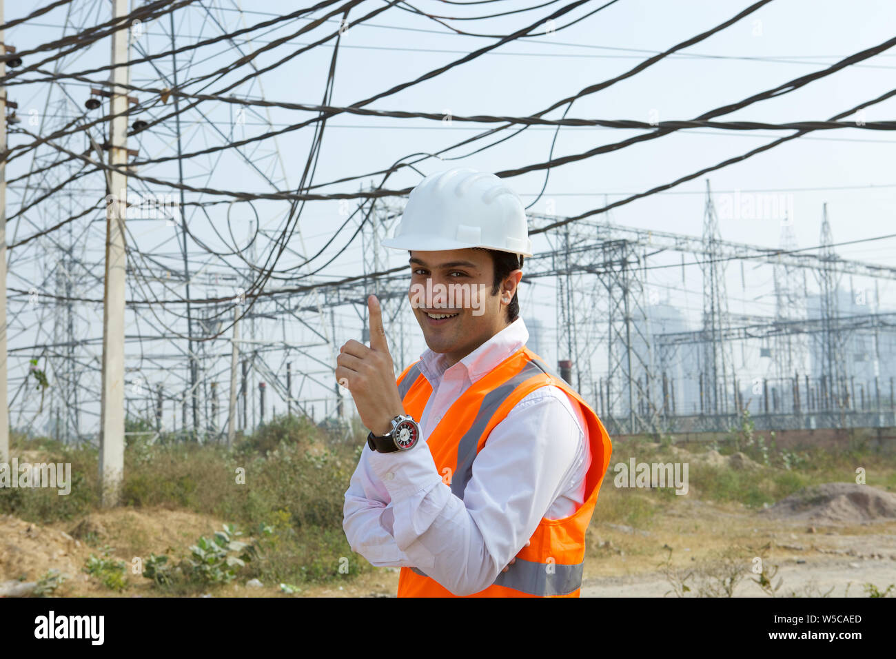Engineer pointing upward and smiling Stock Photo - Alamy