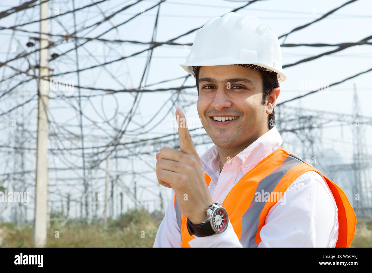 Engineer pointing upward and smiling Stock Photo - Alamy