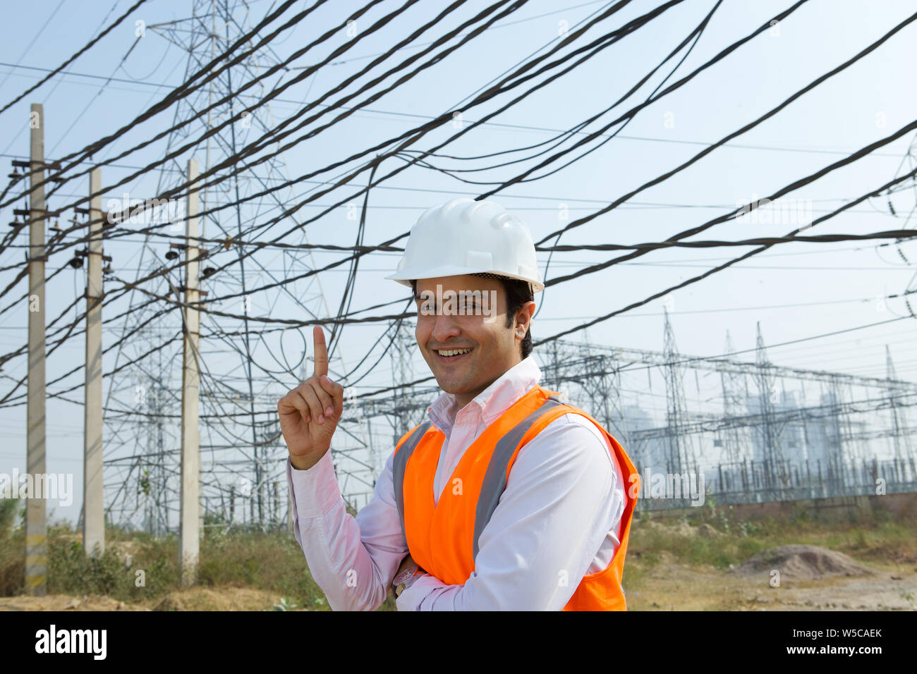 Engineer pointing upward and smiling Stock Photo - Alamy
