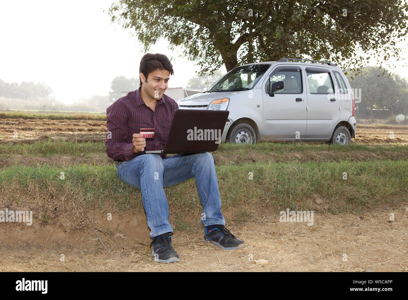 Man doing online shopping in a field Stock Photo - Alamy
