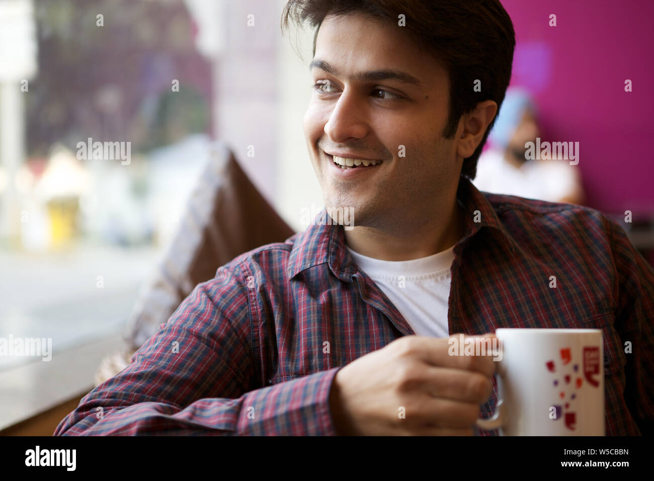 Indian young man having a cup of coffee in a cafeteria Stock Photo - Alamy