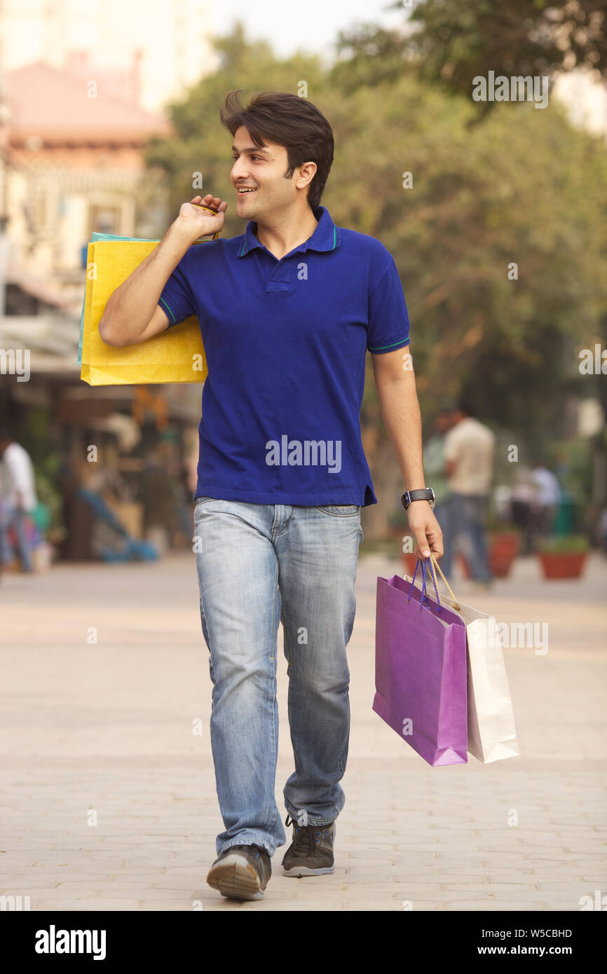 Man carrying shopping bags and smiling Stock Photo - Alamy