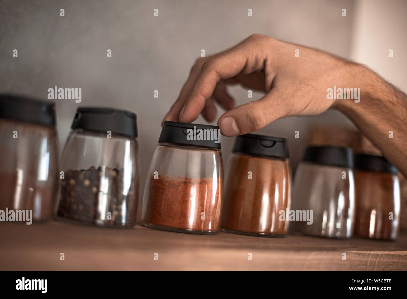close up. a man chooses spices in the kitchen Stock Photo - Alamy