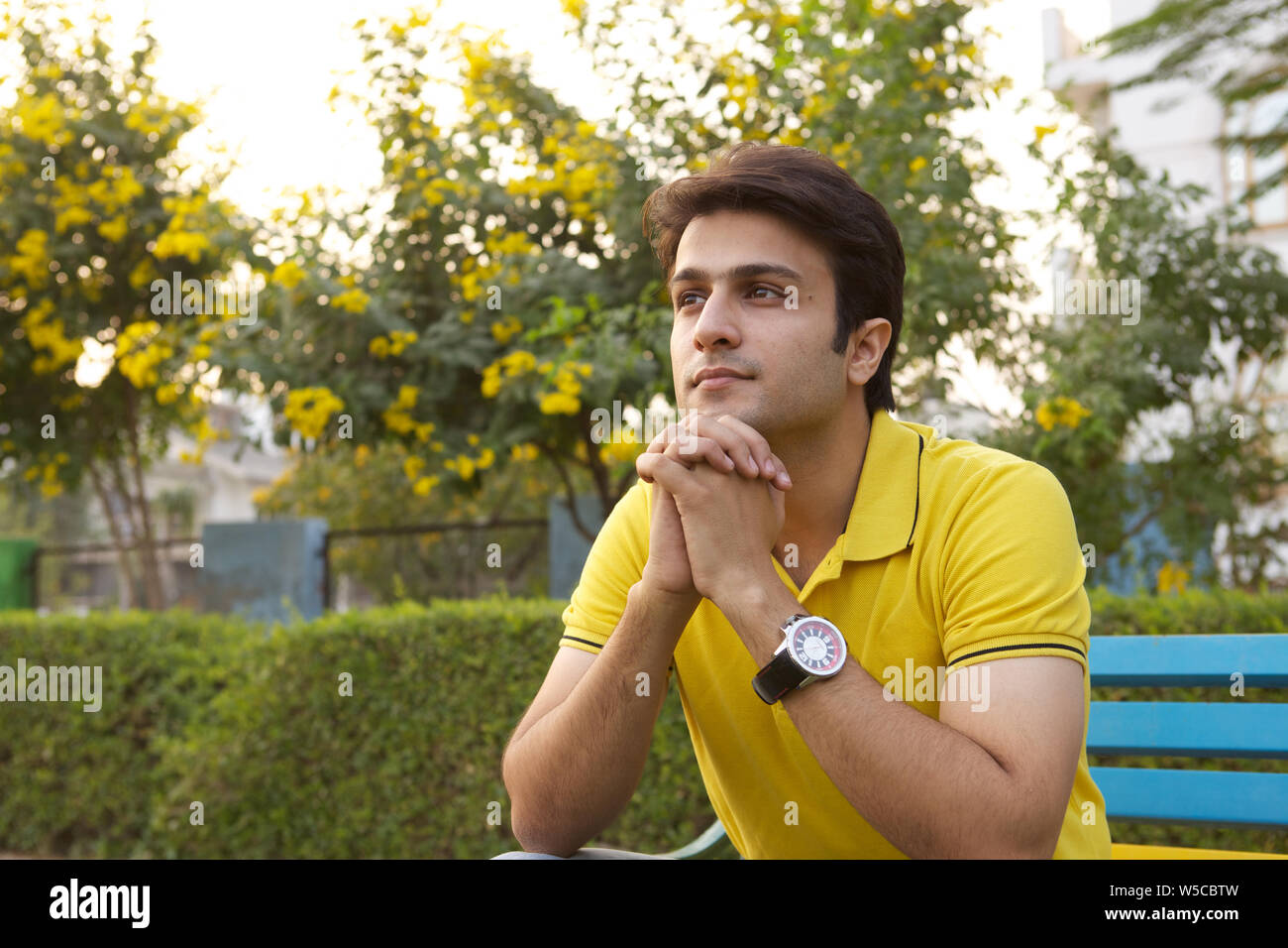 Man sitting on a park and thinking Stock Photo - Alamy