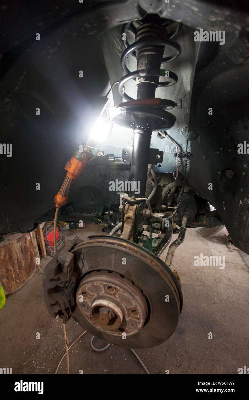 car in service. mechanical work on shock absorber, suspension component ...