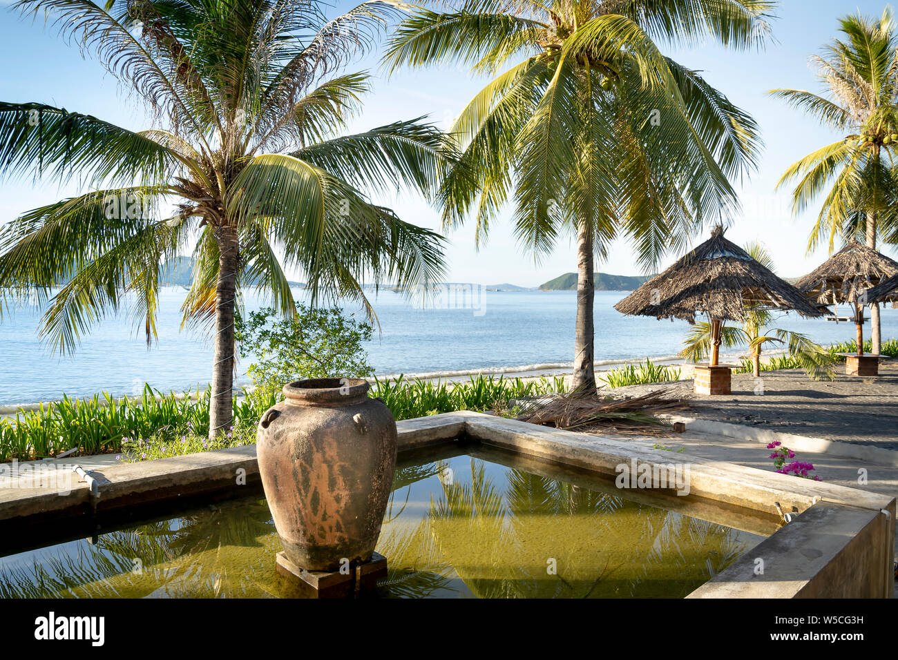 Ornamental water jars under coconut trees overlooking Xuan Dai bay of ...
