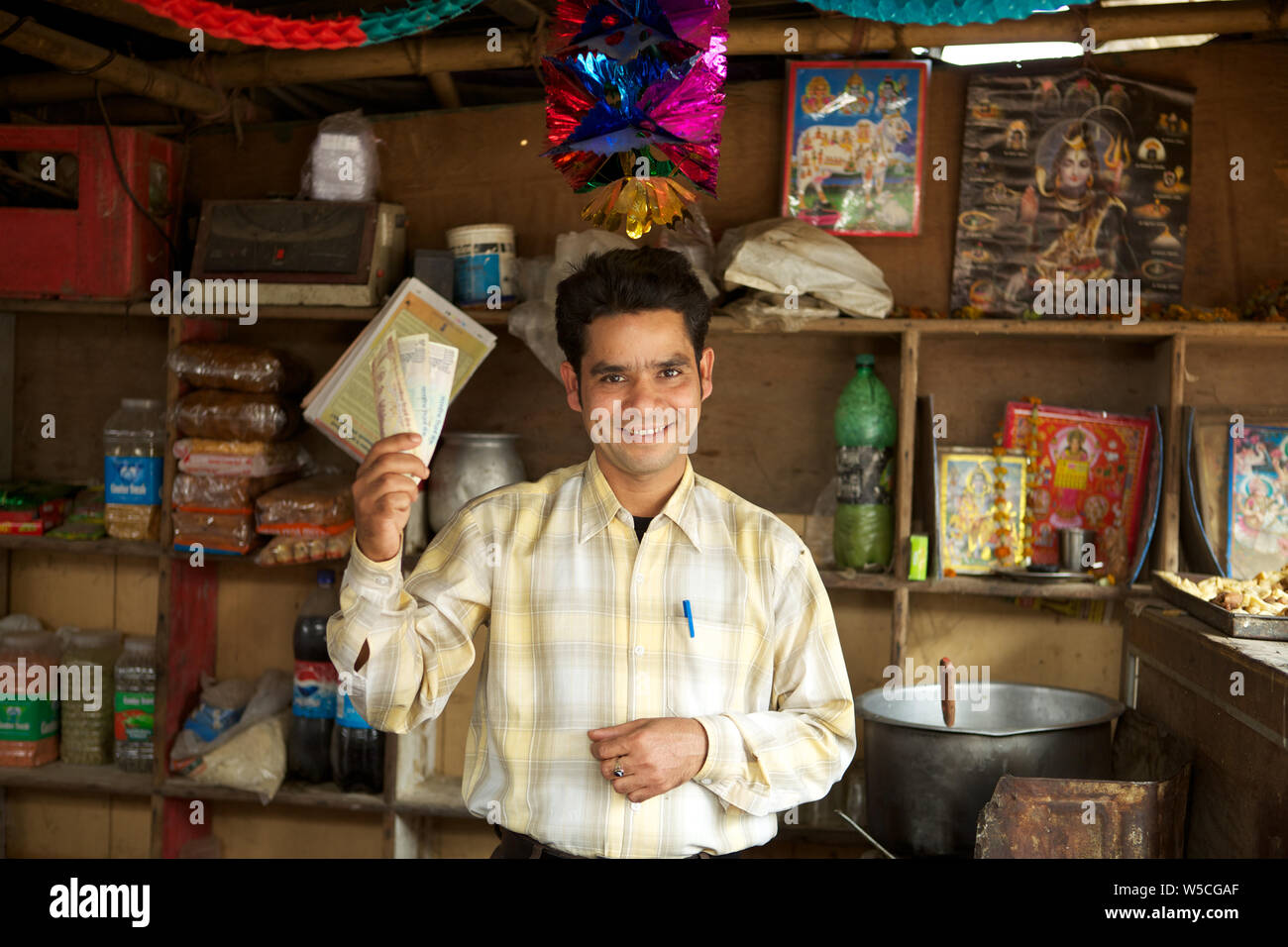 Shopkeeper showing money at a tea stall Stock Photo - Alamy