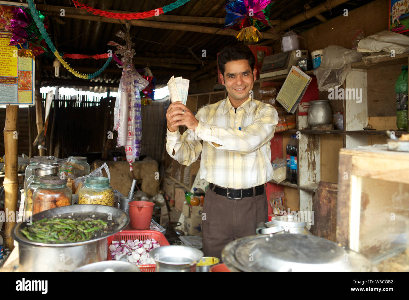 Shopkeeper showing money at a tea stall Stock Photo - Alamy