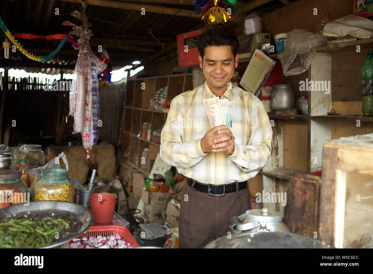 Shopkeeper showing money at a tea stall Stock Photo - Alamy