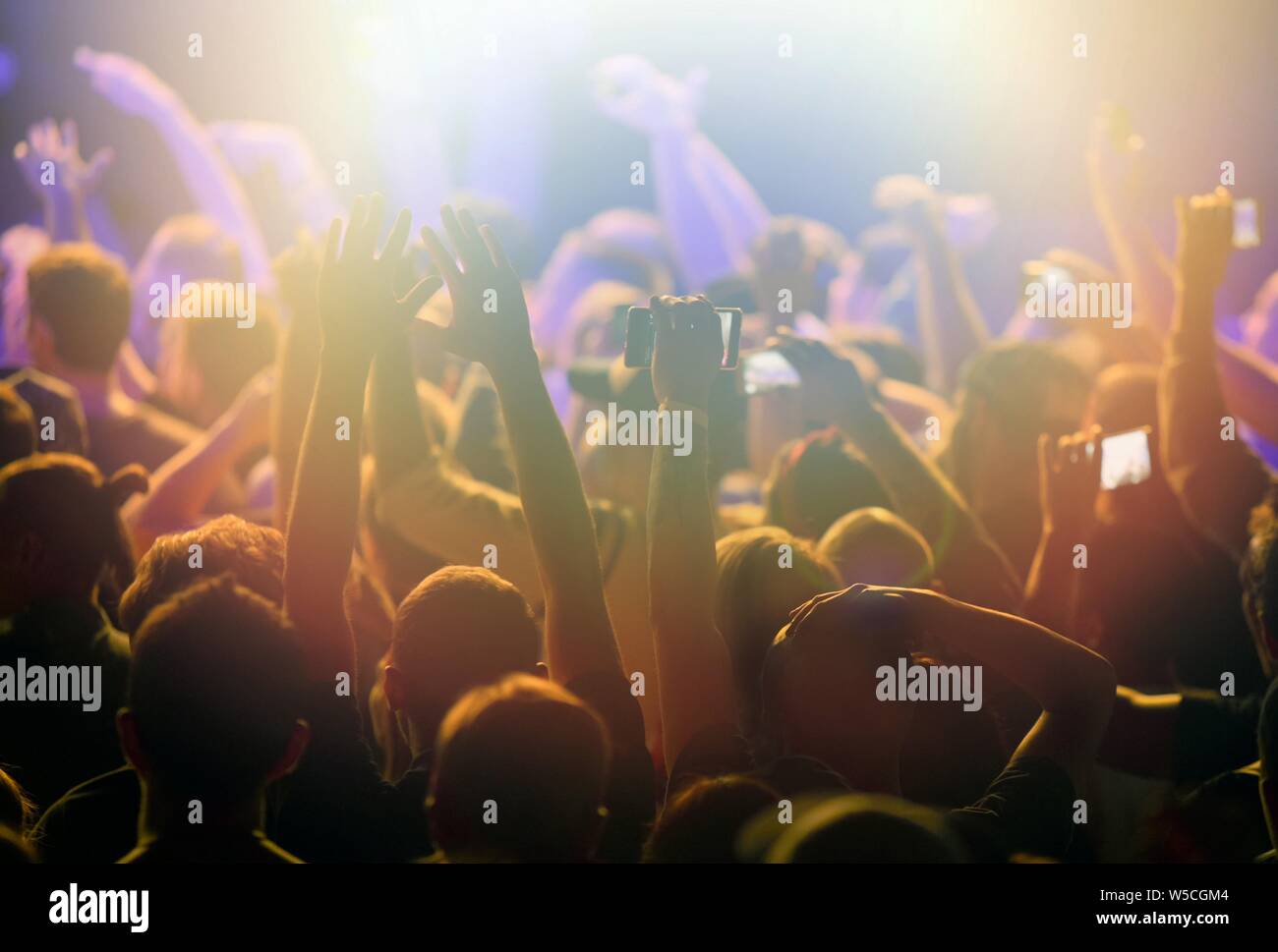 Rap concert audience taking photos with smartphones and wave hands to ...