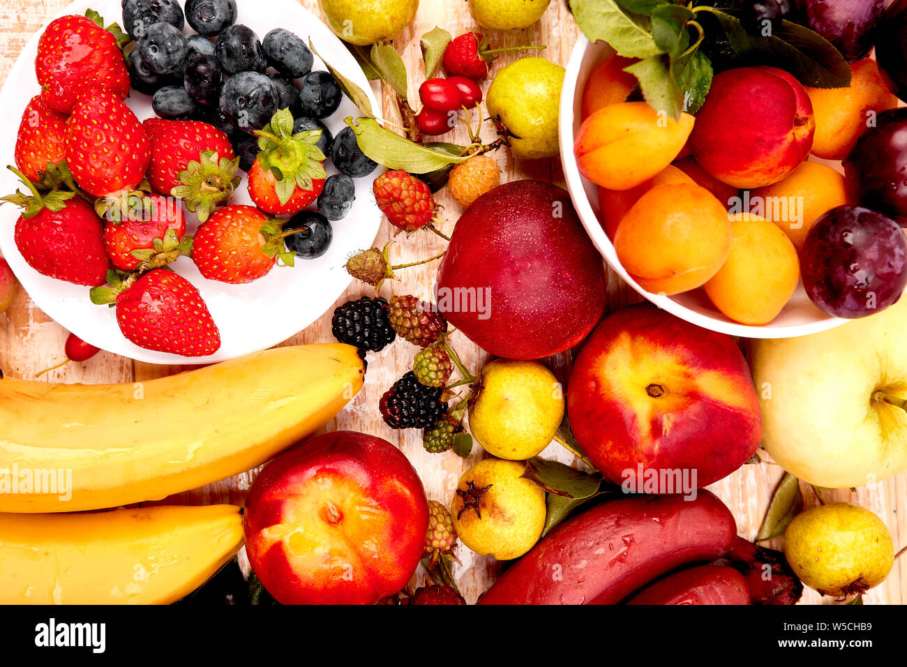 Flat lay of fruits over white wooden background, top view. Vegetarian ...