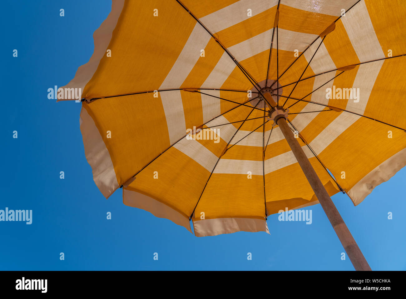 a bright yellow parasol stretched out on the beach Stock Photo - Alamy