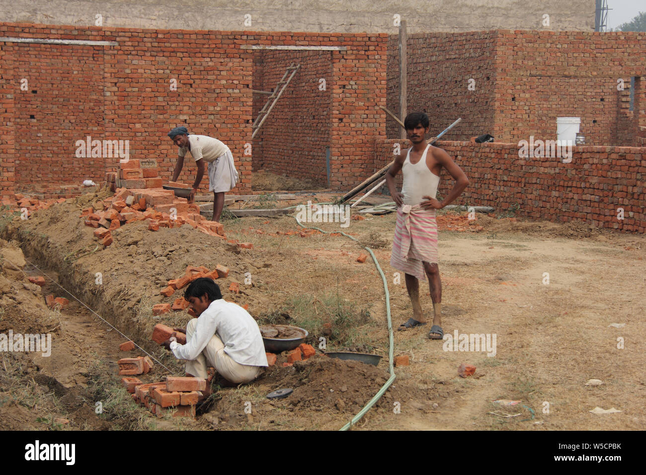 Mason with labour working at a construction site, Haryana, India Stock ...