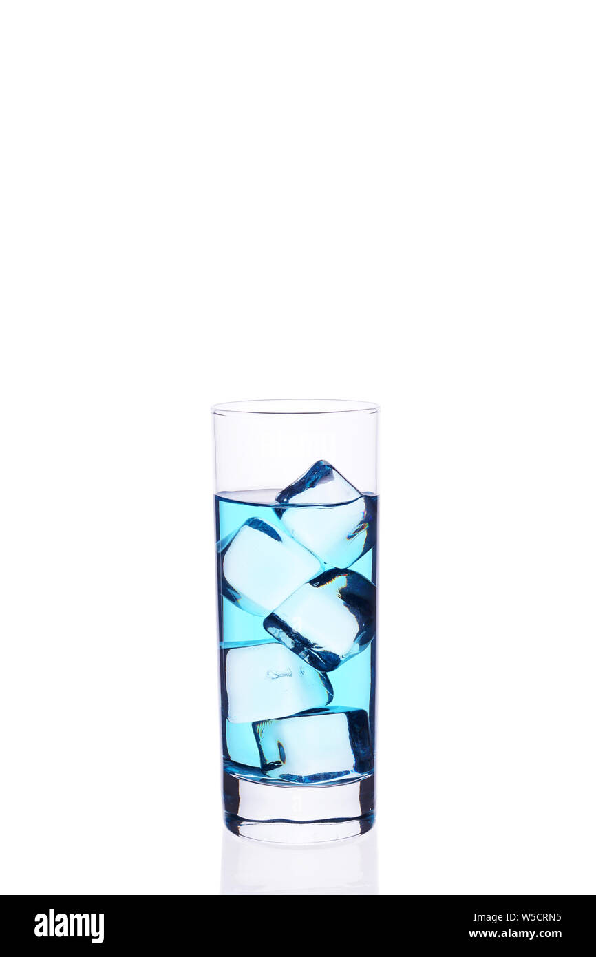 Glass beaker is filled with a blue cocktail ice cubes on a white ...