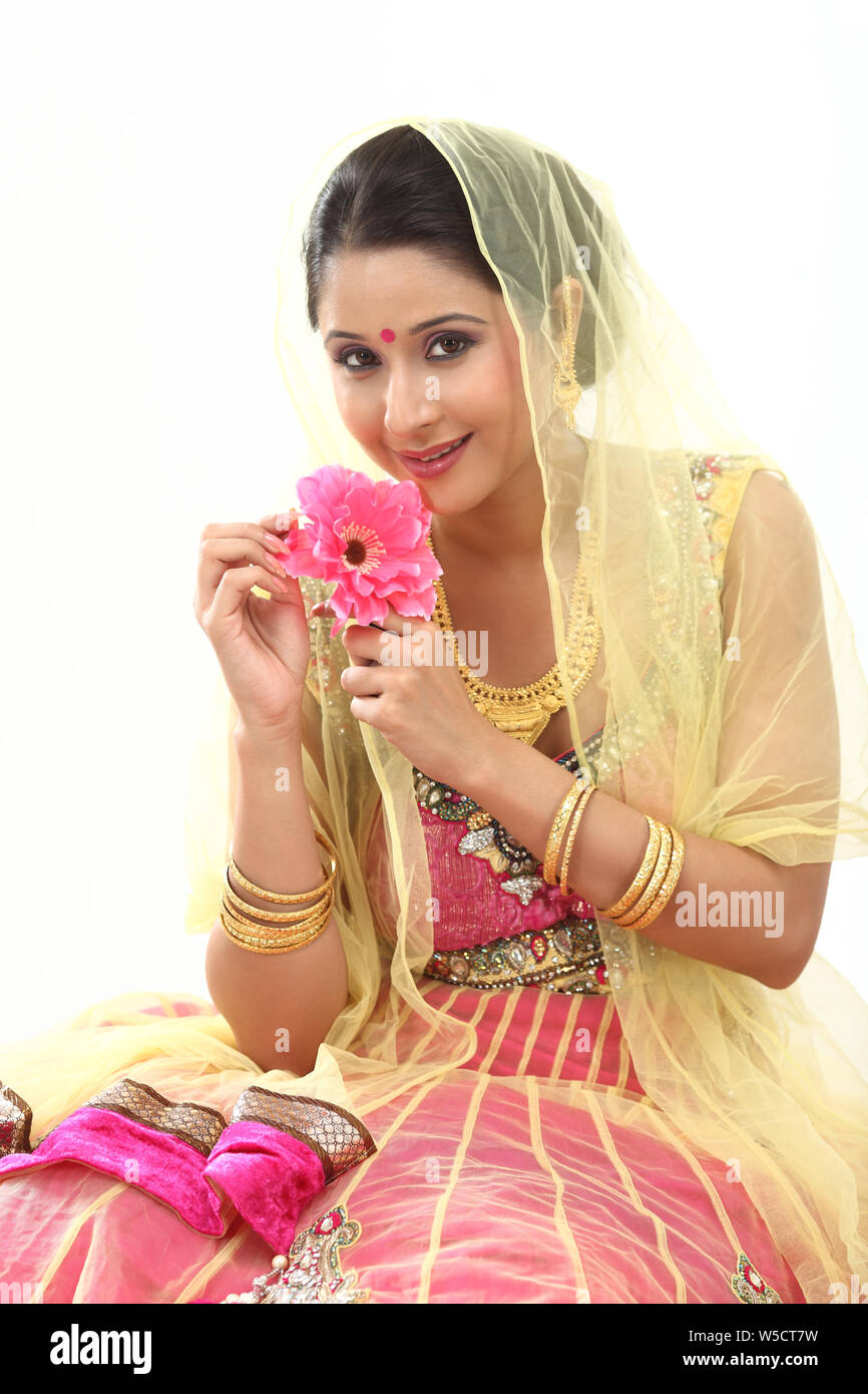 Indian bride holding a pink flower Stock Photo - Alamy
