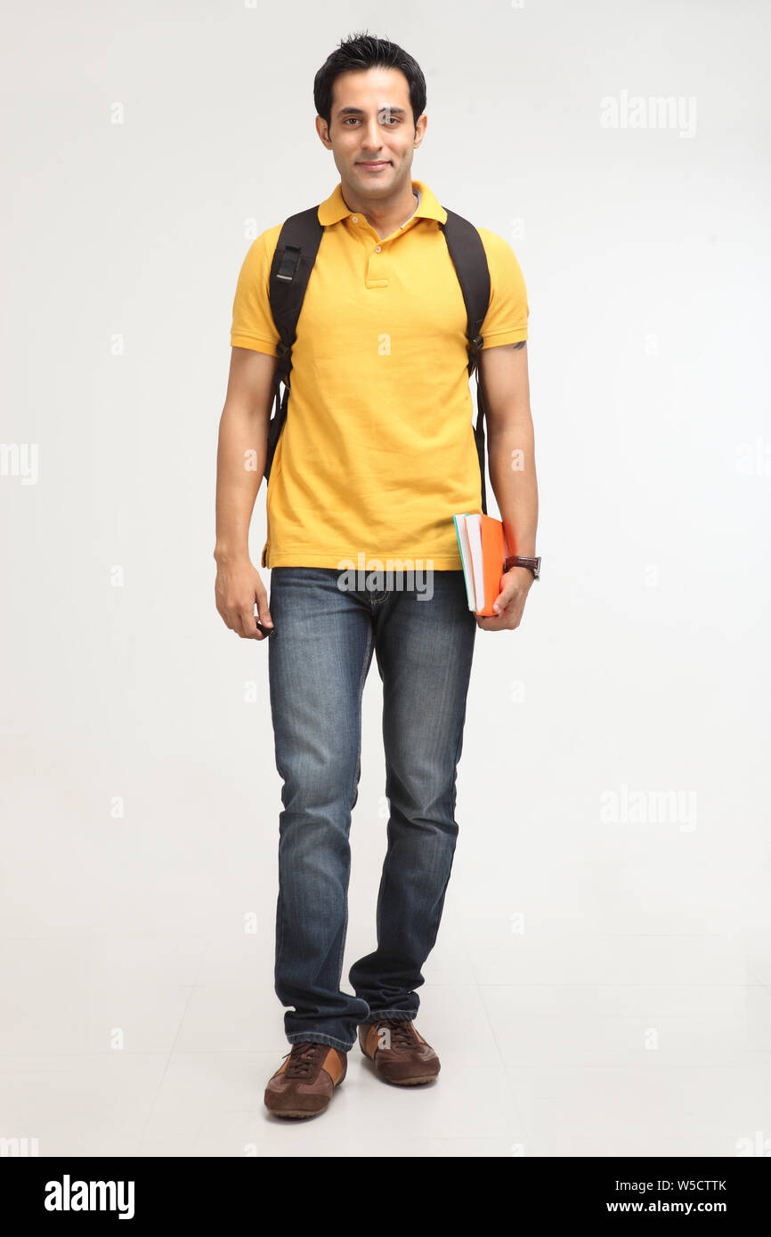 College boy standing with books Stock Photo - Alamy