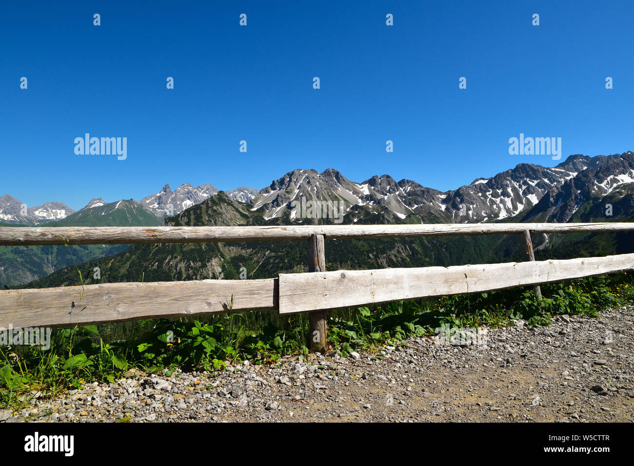 Wooden fence with mountain peaks in background Stock Photo - Alamy