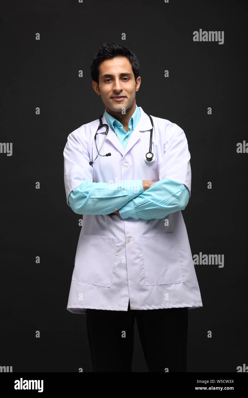 Male doctor standing with his arms crossed Stock Photo - Alamy
