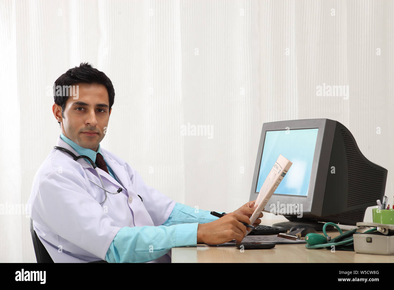 Male doctor holding a newspaper Stock Photo - Alamy