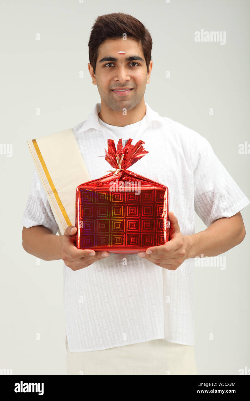 South Indian man holding a gift box Stock Photo - Alamy