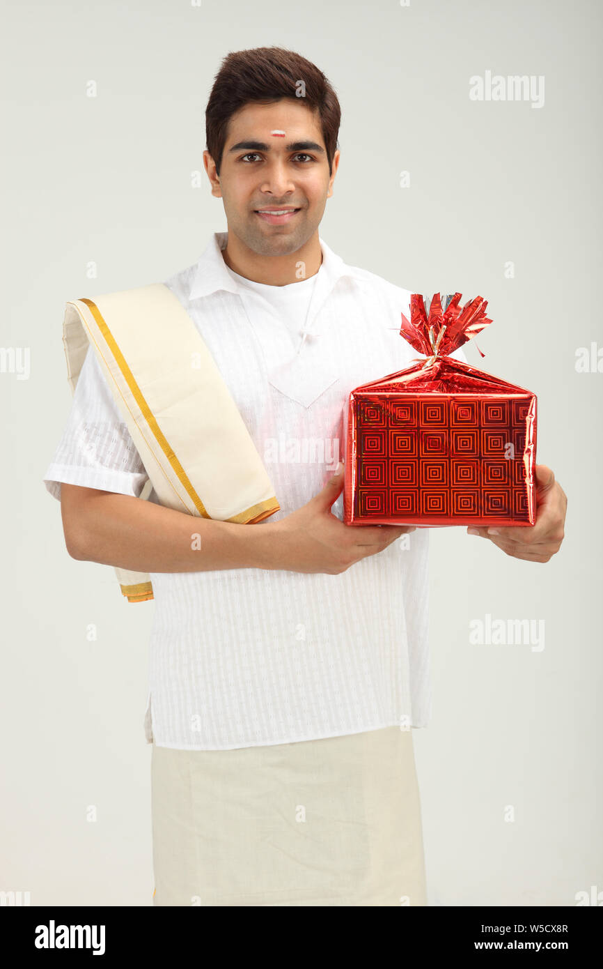 South Indian man holding a gift box Stock Photo - Alamy
