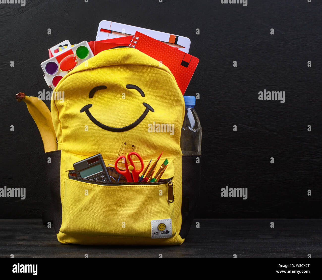 Yellow school backpack with accessories on black background Stock Photo ...