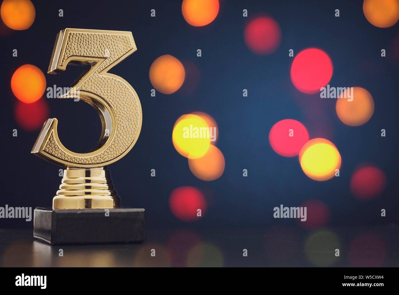 Sharp close up on single isolated gold colored plastic statue of number ...