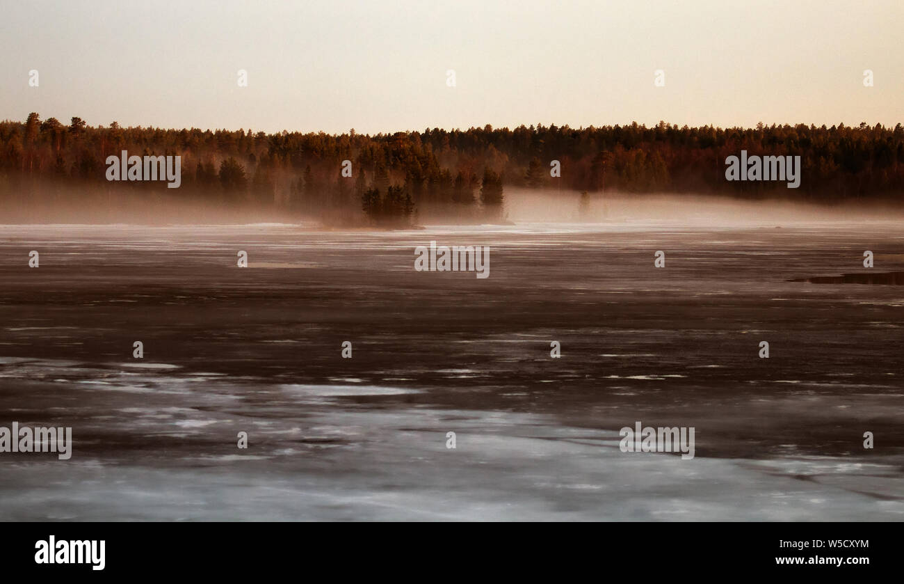 Spring late evening on a lake with fog, remains of ice and disturbing ...