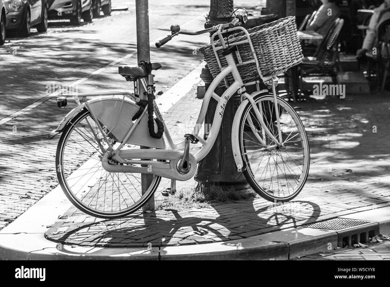 single bike leaning on post on street corner Stock Photo - Alamy