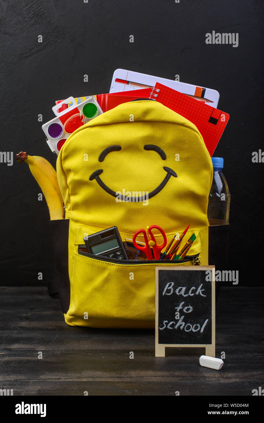 Yellow school backpack with accessories on black background Stock Photo ...