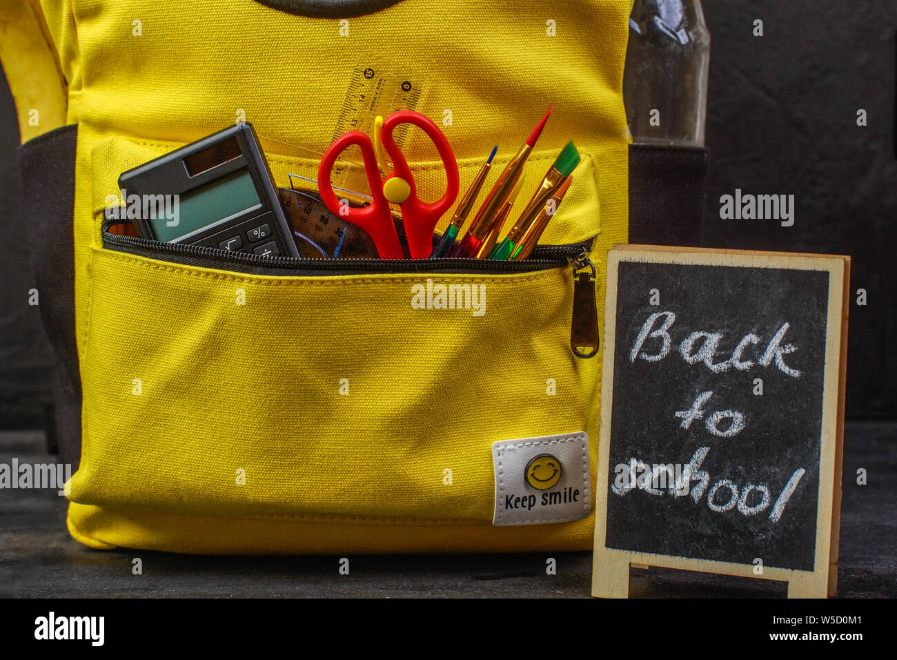 Yellow school backpack with accessories on black background Stock Photo ...