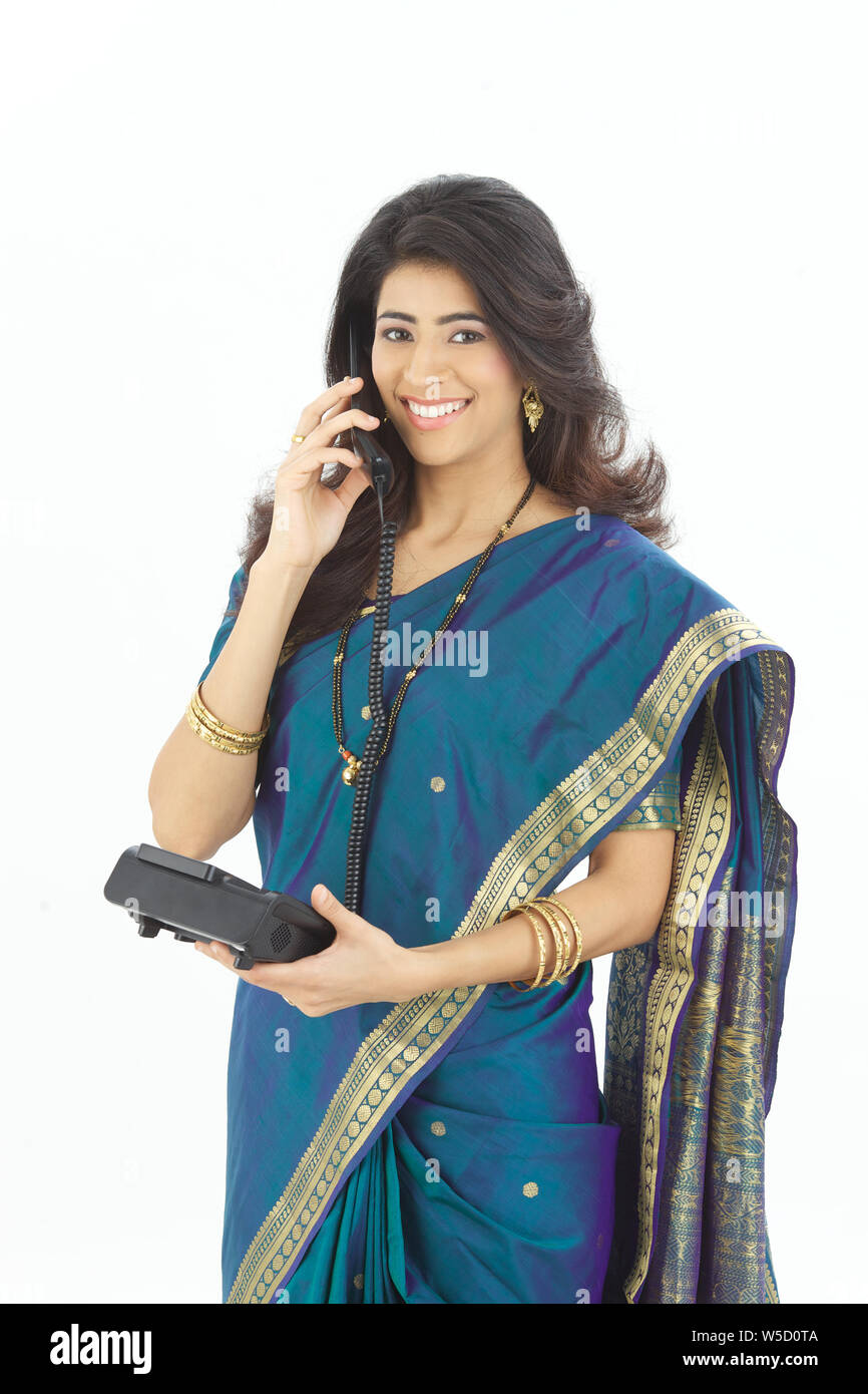 Woman talking on landline phone and smiling Stock Photo - Alamy