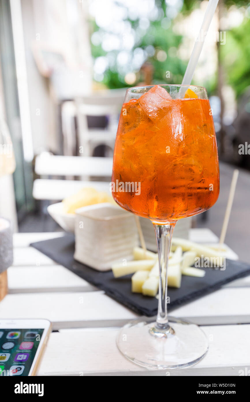 Glass of Aperol Spritz cocktail on the table in restaurant, famous ...