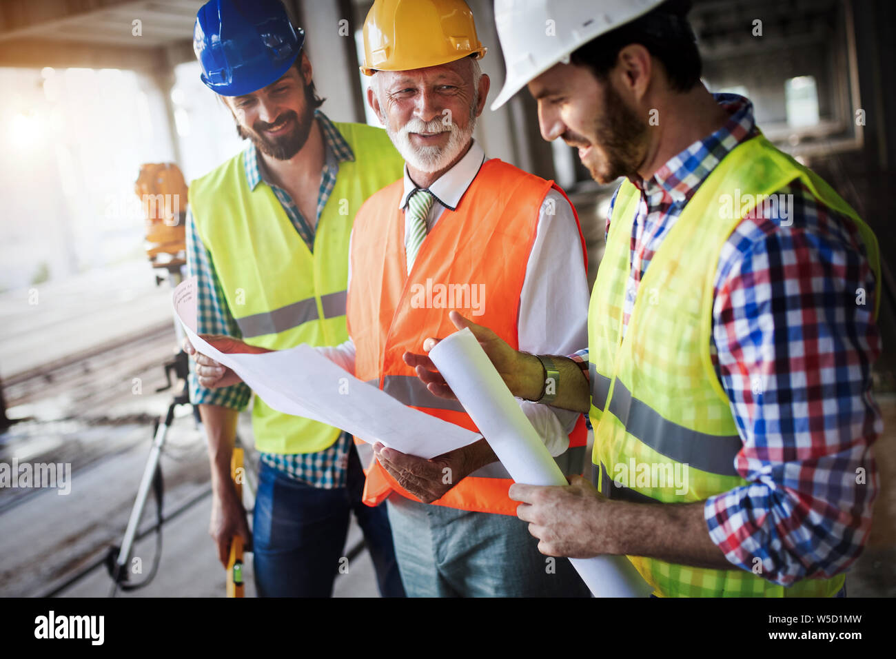 Engineer and construction site manager dealing with blueprints and ...